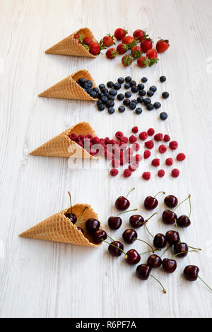 Raspberries, strawberries and blueberries over wooden table with copy ...