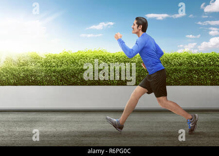Attractive asian man running on the morning at park Stock Photo - Alamy