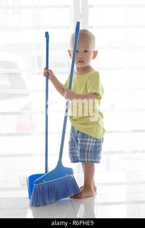 Asian baby boy sweeping floor with broom. Young child doing house ...