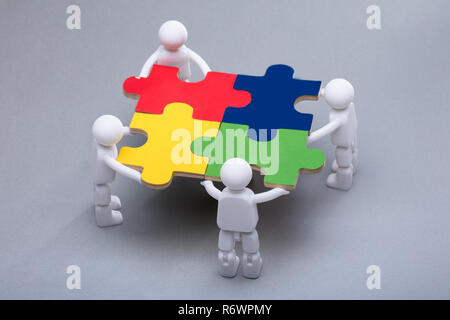 Human Figures Solving Multicolored Jigsaw Puzzle On Grey Background ...