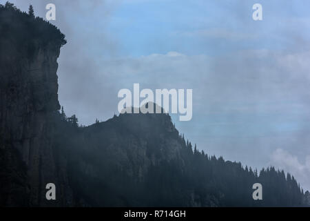 Overhanging cliffs, rocky slopes mountain range with trees Stock Photo ...