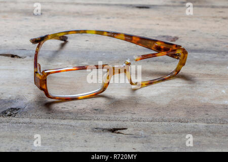 Broken Tortoiseshell spectacles on a rough wooden surface Stock Photo ...