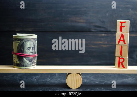 Dollars and the inscription "Fair" on wooden blocks. Balance. Fair ...
