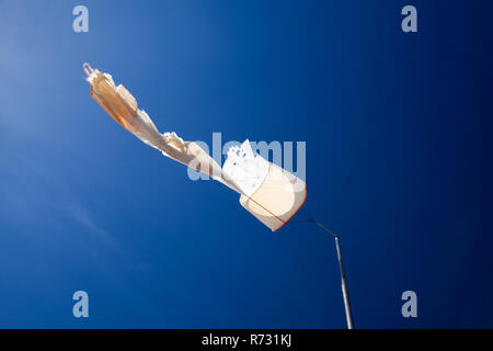 torn windsock against dark blue sky, storm aftermath background Stock ...