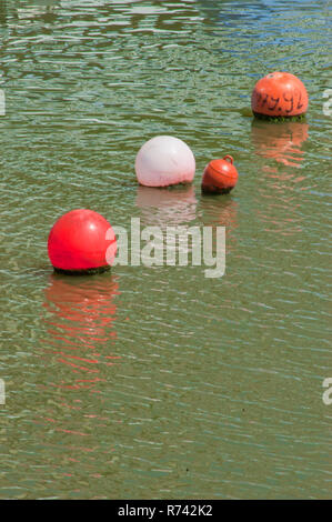 Red maritime navigation buoy floating in turquoise ocean waters near a ...