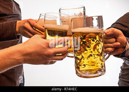 cheers, two mugs of beer toasting creating splash isolated on white ...