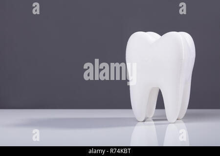 Single White Tooth On Grey Background Stock Photo - Alamy