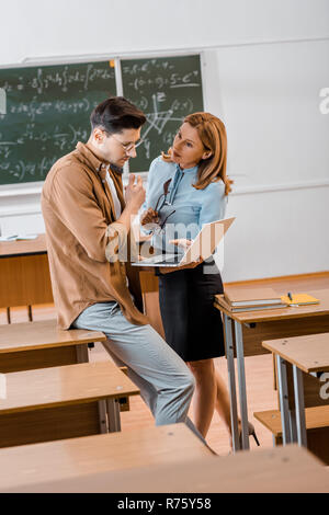 Professional male teacher using laptop in classroom Stock Photo - Alamy