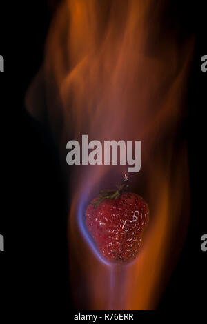 Strawberry on fire with blue flames isolated on black background Stock ...