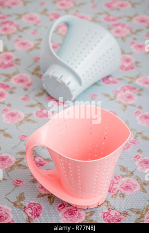 Colorful Plastic Colanders with Handles on Floral Pattern Stock Photo ...