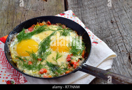 Fried eggs with greens, vegetables and cheese on a frying pan Stock ...