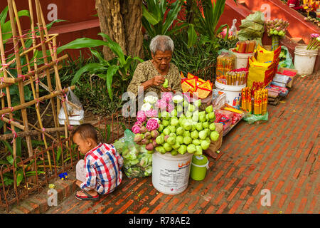 old woman selling lotus flowers and votive paper for Chinese New Year ...