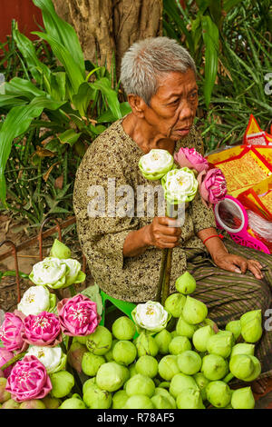 old woman selling lotus flowers and votive paper for Chinese New Year ...