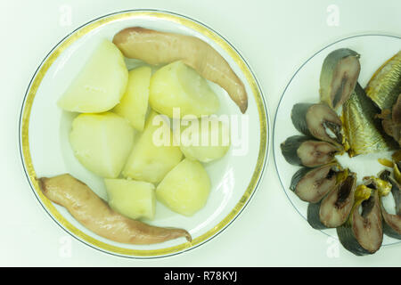 Pieces of mackerel and lemon on a white plate on a white background ...