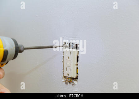 Preparing screws for electrical to install outlet, checking the ...