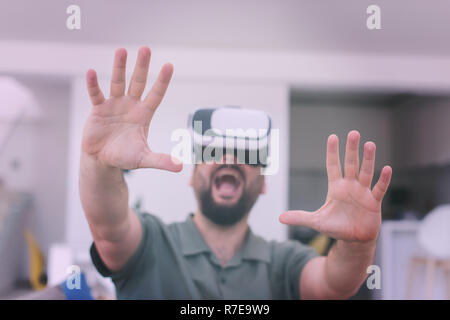 handsome hipster man with beard trying vr glasses at modern home Stock ...