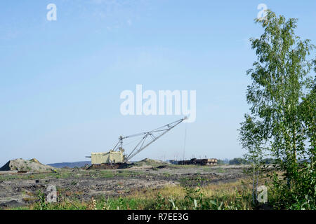 A huge excavator carries rock from the unloaded train. The concept of ...