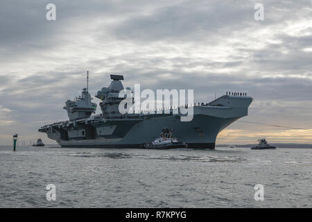 Crew line the decks of the aircraft carrier HMS QUEEN ELIZABETH as it ...