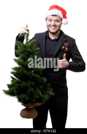 Guy stands by Christmas tree. Santa Claus with cheerful face Stock ...