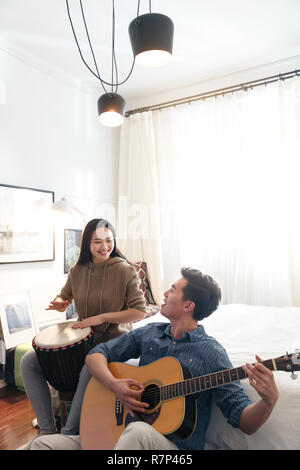 Happy couples playing Musical Instruments at home Stock Photo - Alamy