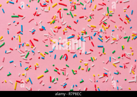 trendy pattern of colorful sprinkles over yellow background, decoration ...