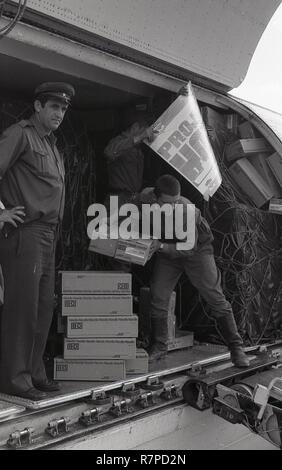 MEN LOADING PACKAGES OFF OF A PLANE Stock Photo - Alamy
