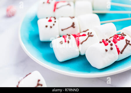 Close up view. Making marshmallow snowman and reindeer on sticks for ...