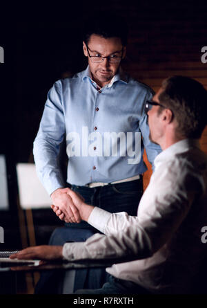 employees shaking hands near the desktop Stock Photo - Alamy