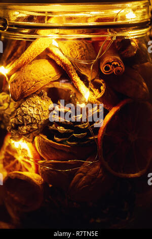 Glass jar with pine cones and garland on dark background. Festive ...