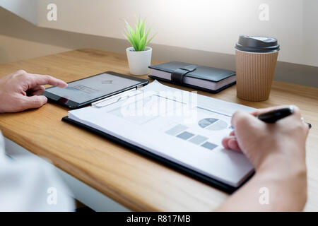 businessman going through some paperwork and signing a document at desk ...