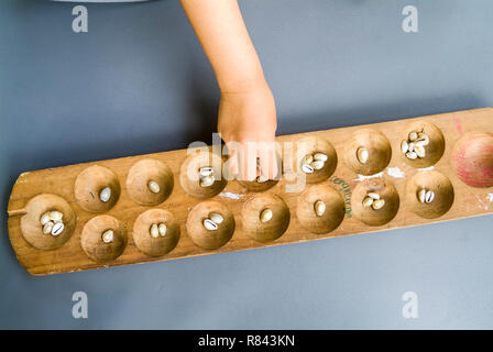 the hand of girl is playing Indonesian traditional mancala games Stock ...