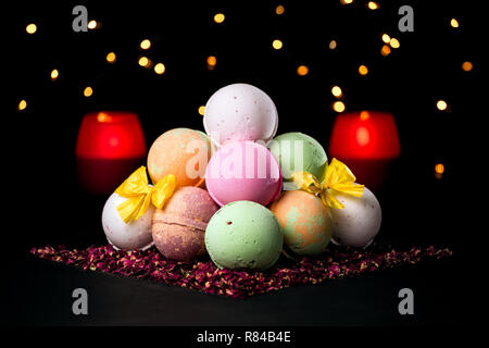 Pyramid of colorful bath bombs on the dark background surrounded by ...