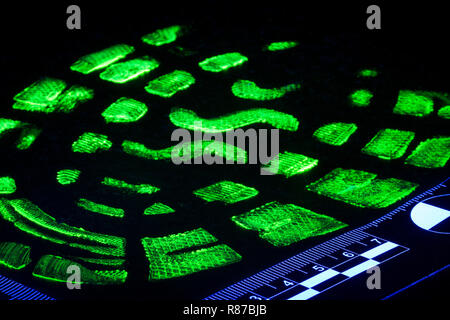 Dust fingerprint powder impression of a boot or shoe left on a masonite ...