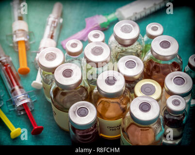 Different types of vials with medication along some syringes in a ...