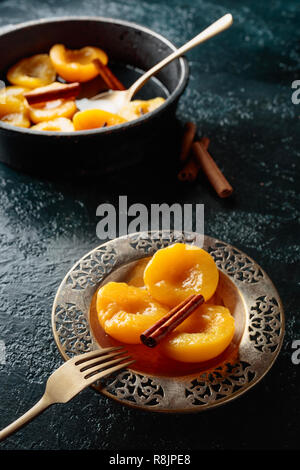 Peach dessert with cinnamon and cloves on a dark background Stock Photo ...