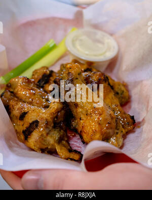 crispy fried chicken wings served on a clay plate on a wooden table ...