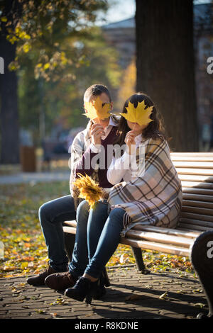 Loving couple cover your face with autumn leaves in the park Stock ...
