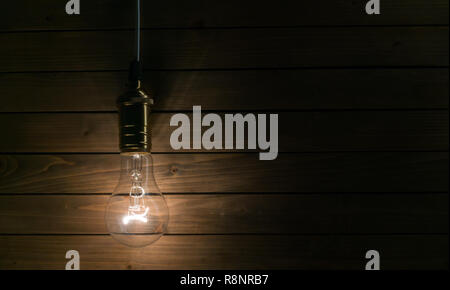 The light bulb illuminates on wooden background Stock Photo - Alamy