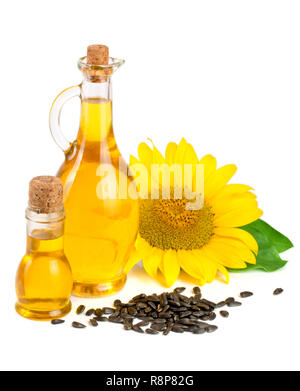 Jug of oil, sunflower and jar with seeds on brown background Stock ...