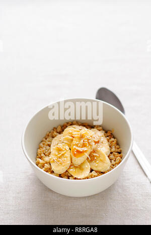 Oatmeal served in white ceramic bowl garnished with red yellow cherries ...