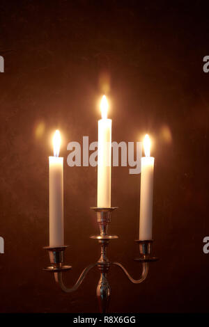 quiet home environment at night by candlelight. White candles burn in ...
