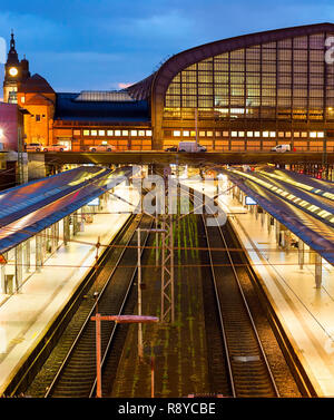 evening train traffic with rails and illuminated platform in the dark ...