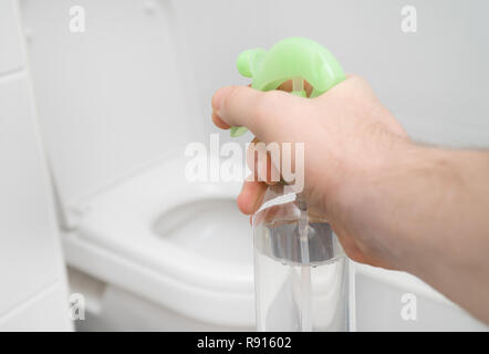 Male hand spraying toilet air freshener at home Stock Photo - Alamy