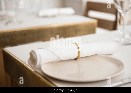 A wooden dining table set with empty plates indoor. Restaurant interior ...