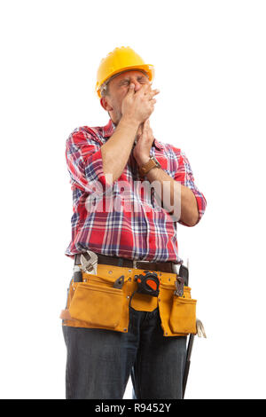 Sleepy builder covering mouth while yawning as tiresome hard work ...