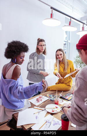 African american woman artist drawing on notebook having video call at ...