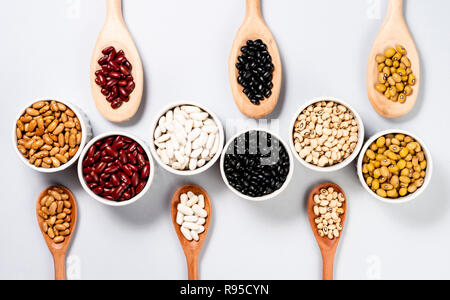 Assortment of beans in pots and wooden spoons on gray background Stock ...