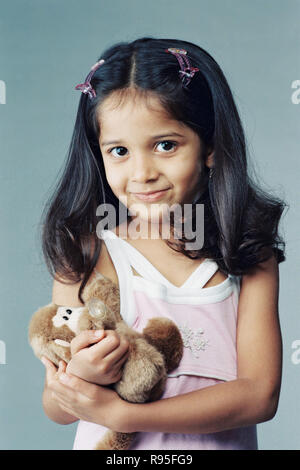 Girl cuddling soft toy monkey Stock Photo - Alamy