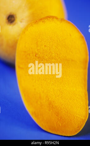 Two whole mangoes and one half of mango on black background with text ...