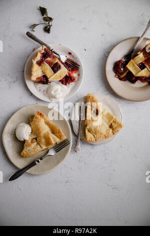 Slices of various pies in little plates. Overhead view, concrete ...